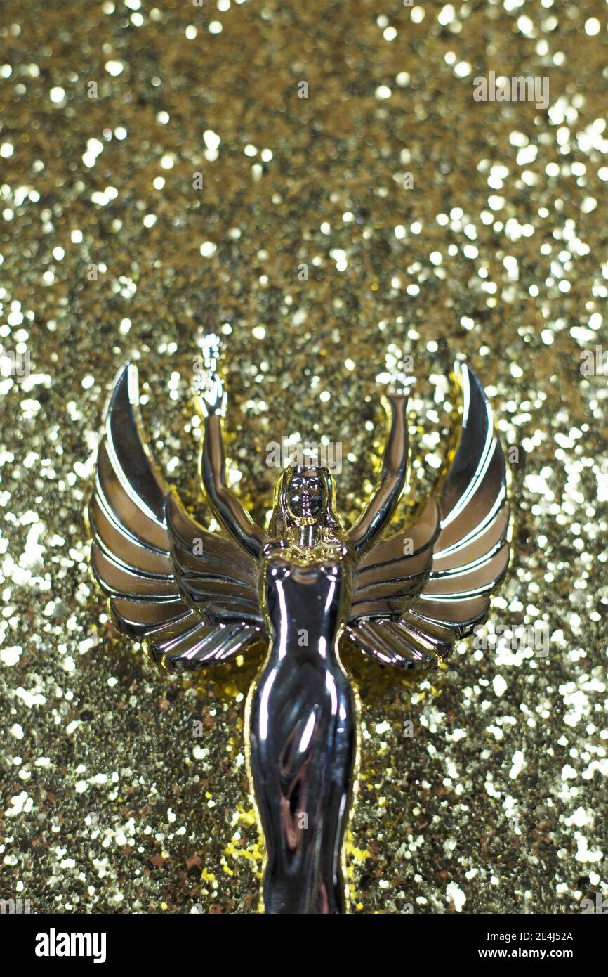 Still life of a trophy of a winged triumphant gold woman against a ...