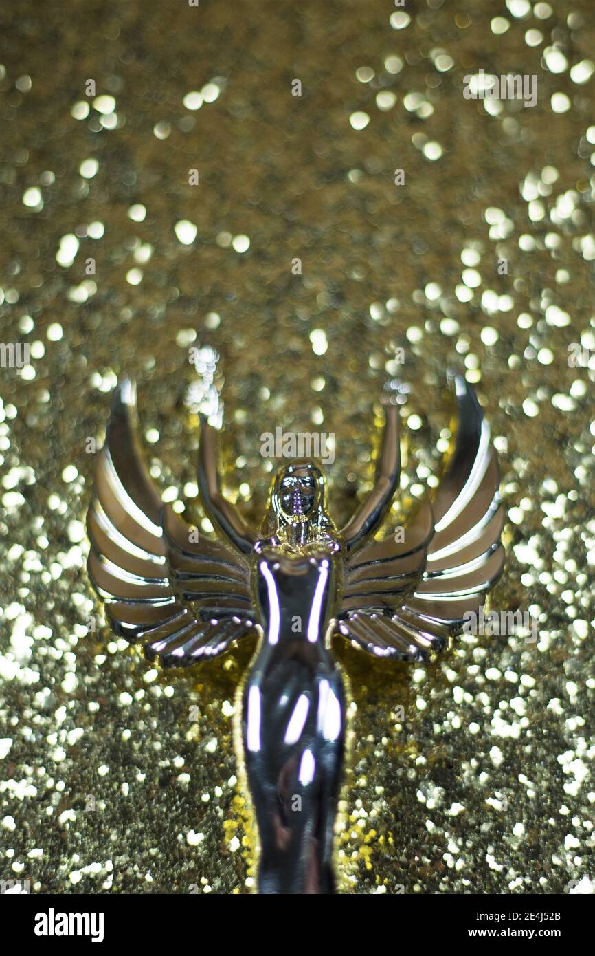 Still life of a trophy of a winged triumphant gold woman against a ...