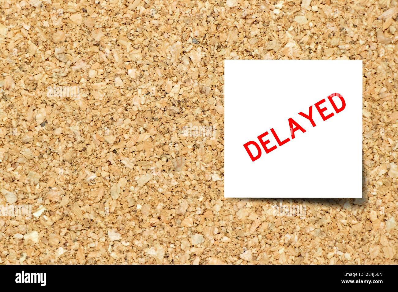 White note paper with word delayed on corkboard background Stock Photo ...