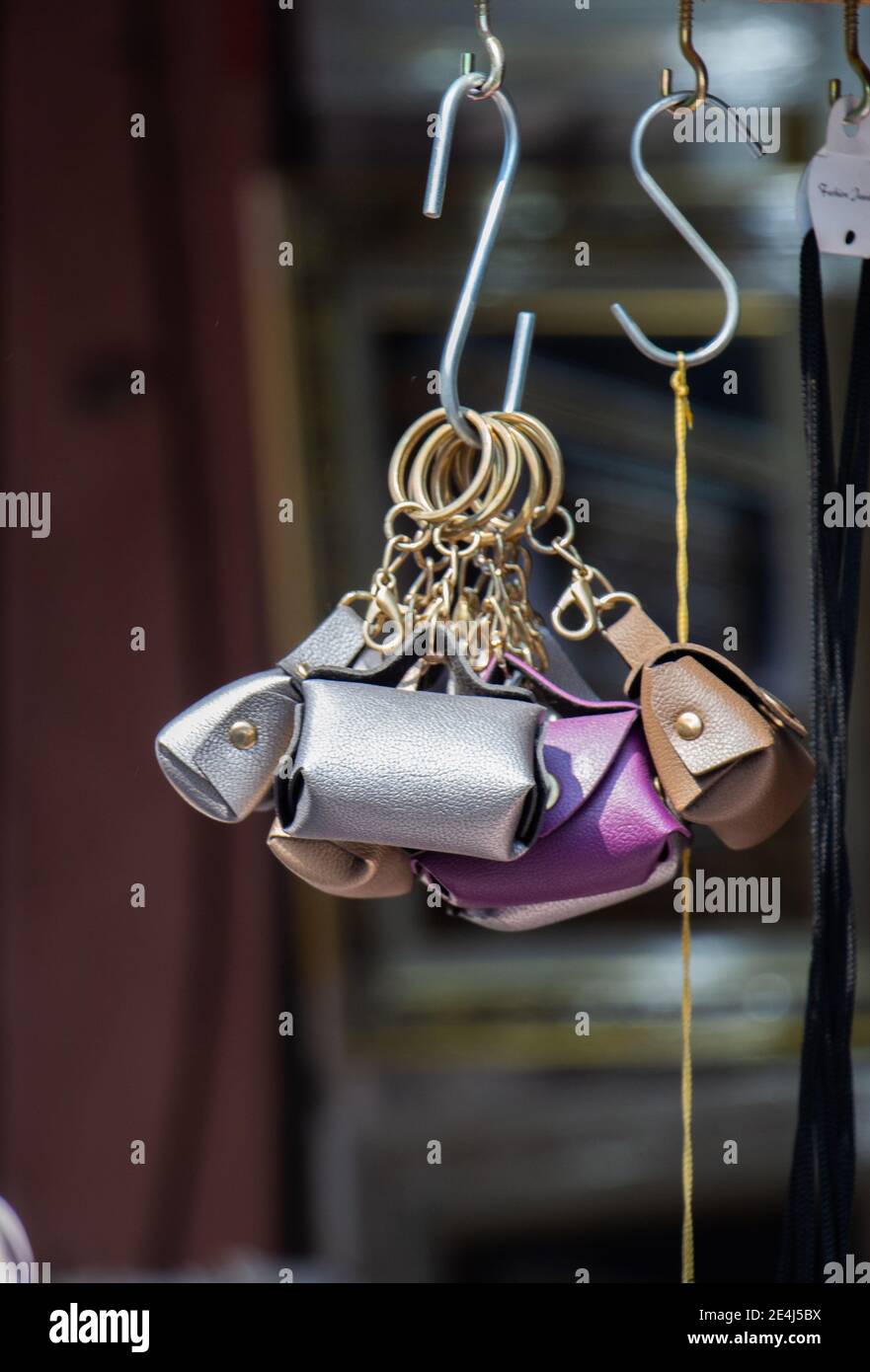 A vertical shot of mini wallet with keychains hanging on hook display ...