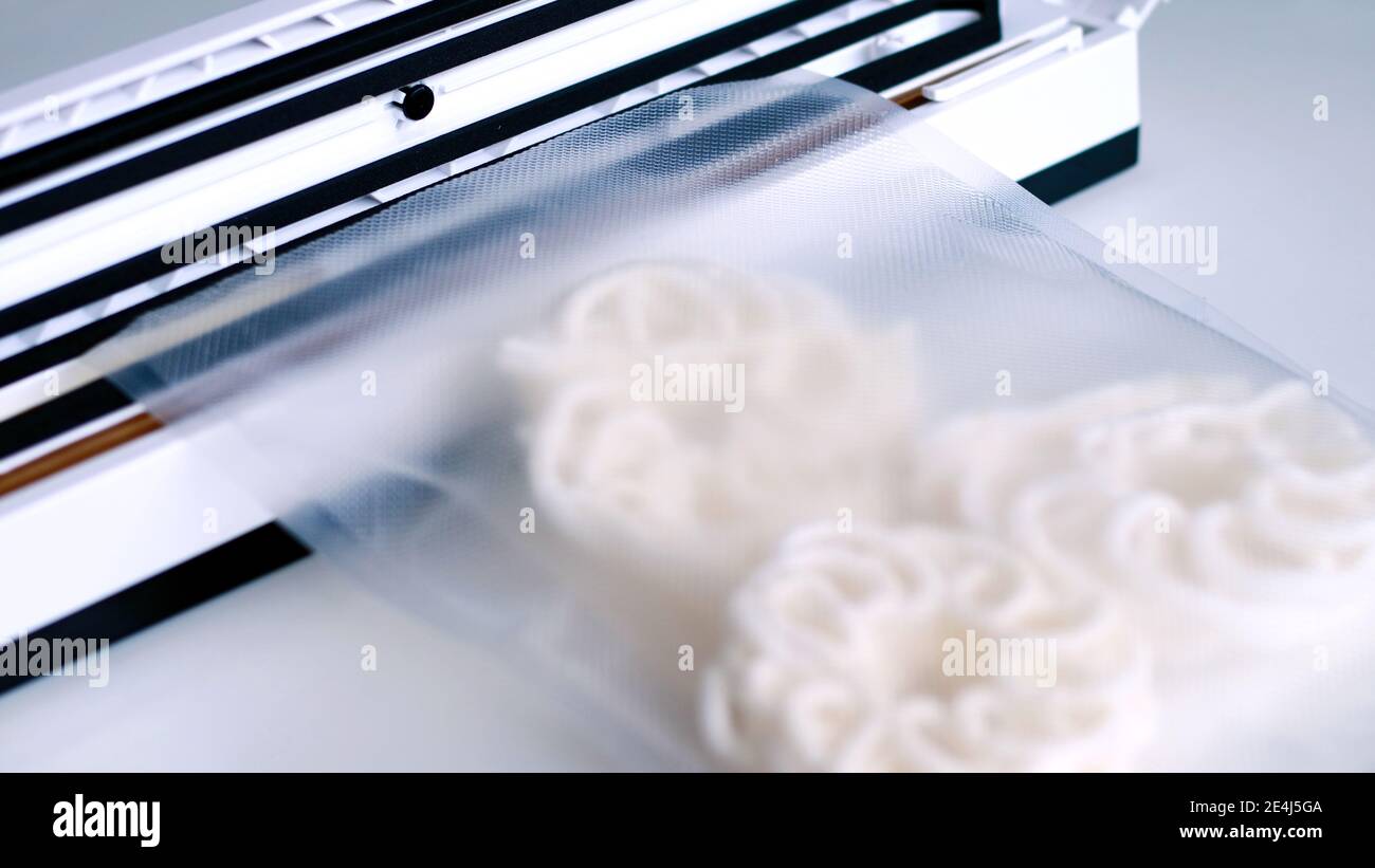 Wrap food using a vacuum sealer machine Stock Photo - Alamy