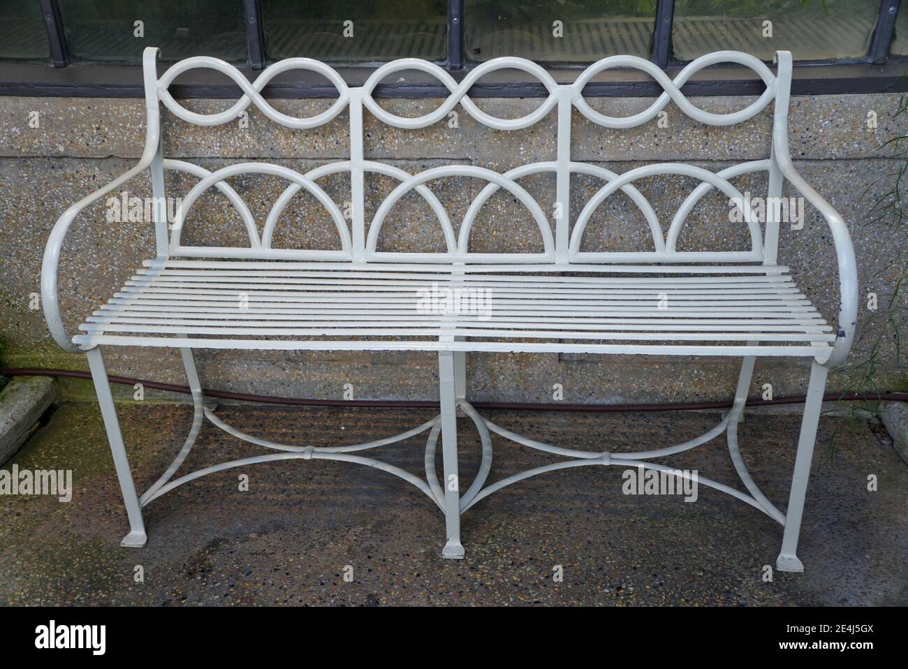 A white painted metal bench for the indoor use Stock Photo - Alamy