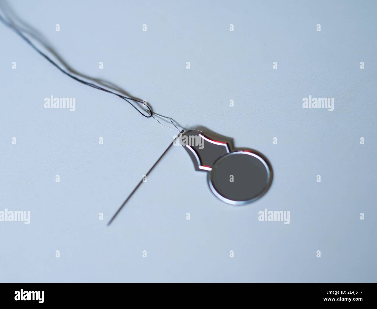 Needle threader on white background. Needle threader is a device for ...