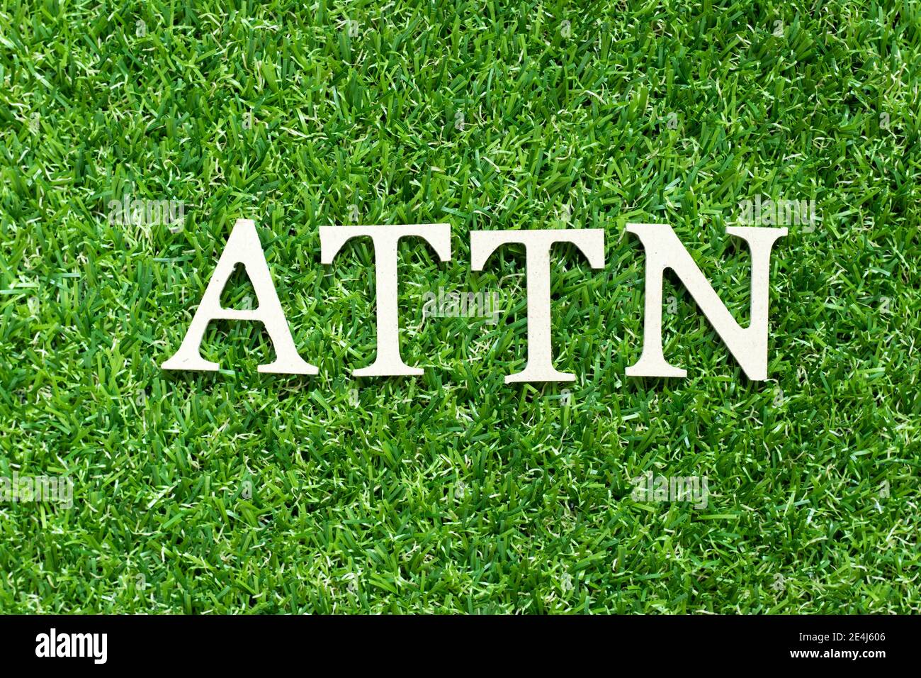 Alphabet letter in word attn (Abbreviation of attention) on green grass ...
