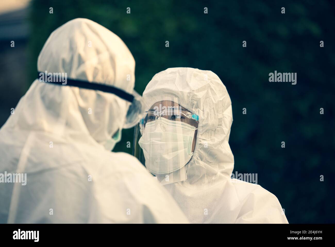 Asian doctor wearing ppe suit and face mask in hospital or outside ...