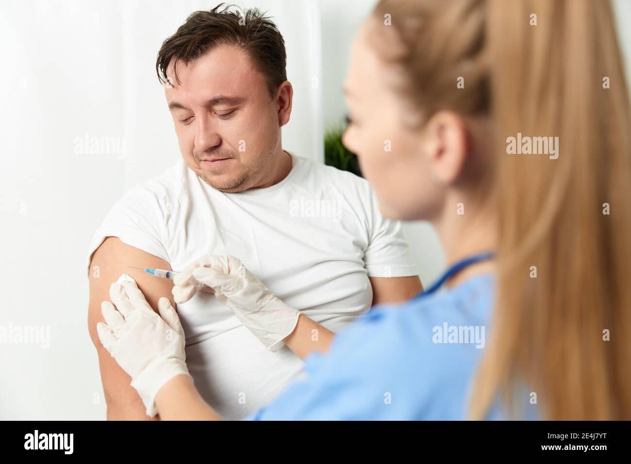 a doctor gives an injection to a man's hand health vaccination Stock ...