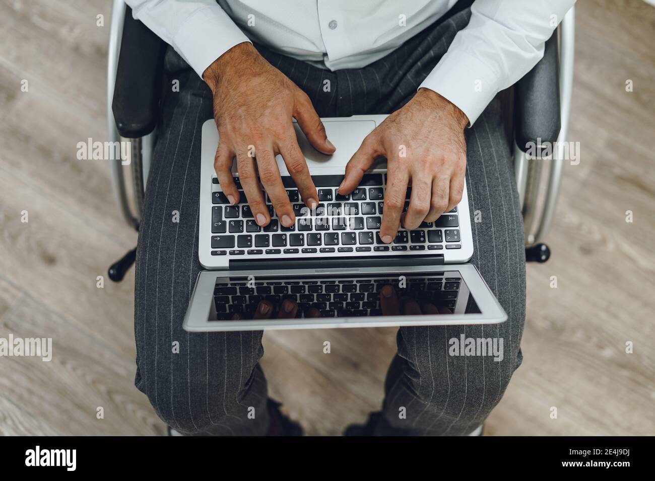 Disabled man in a wheelchair using laptop Stock Photo - Alamy