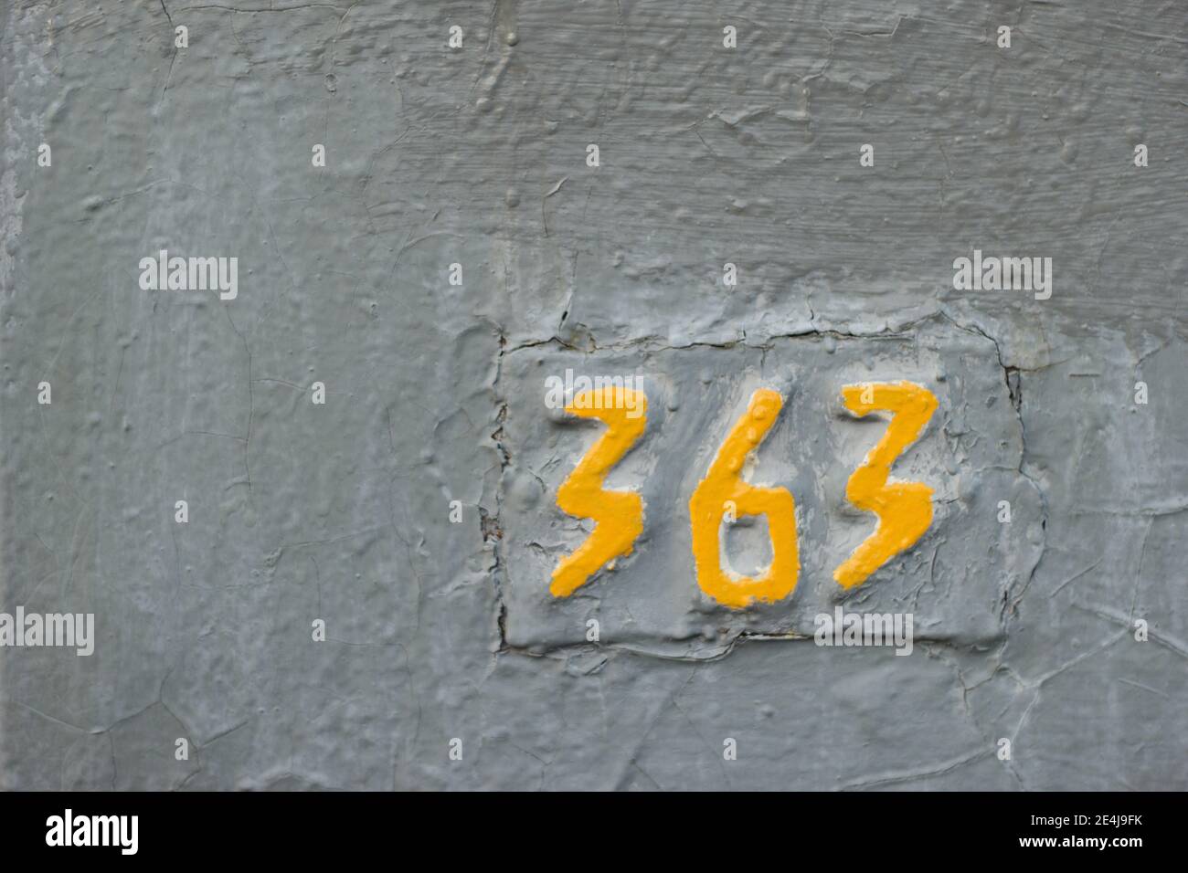 The house number 363 in yellow on a weathered concrete wall Stock Photo ...