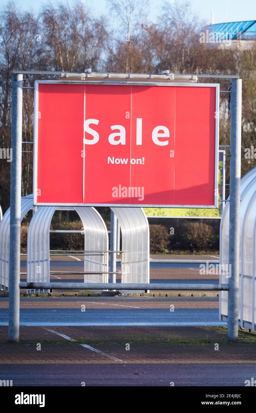 Sale sign red banner in retail shop car park next to trolley store ...