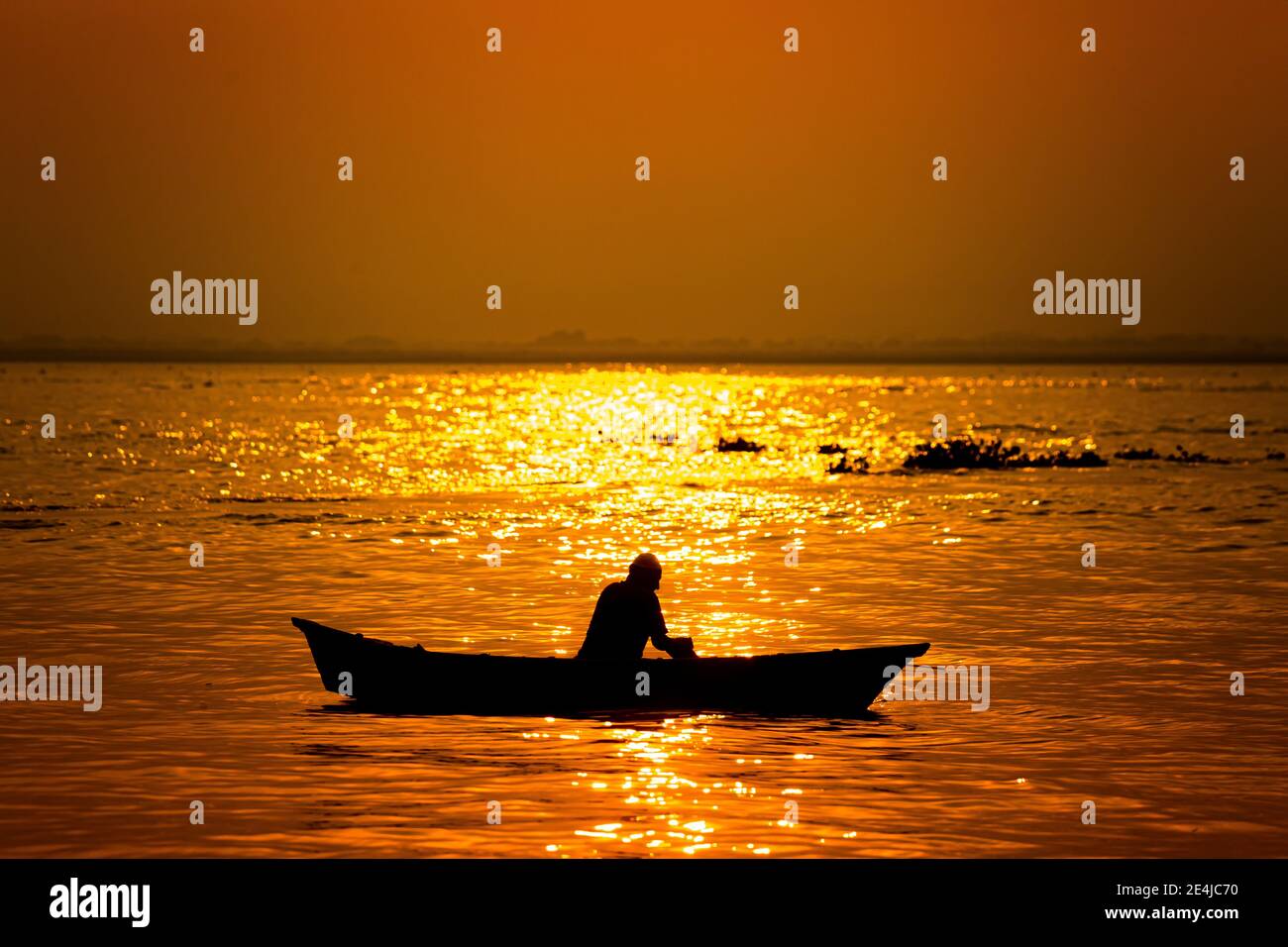 Evening golden sunset time, a fisherman fishing on the seaside on a ...