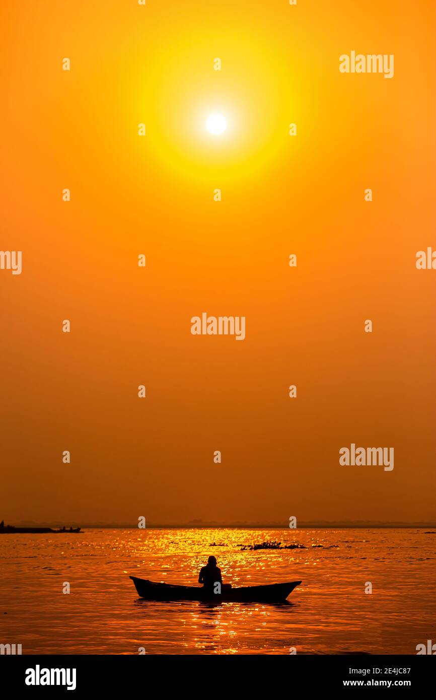 Evening golden sunset time, a fisherman fishing on the seaside on a ...