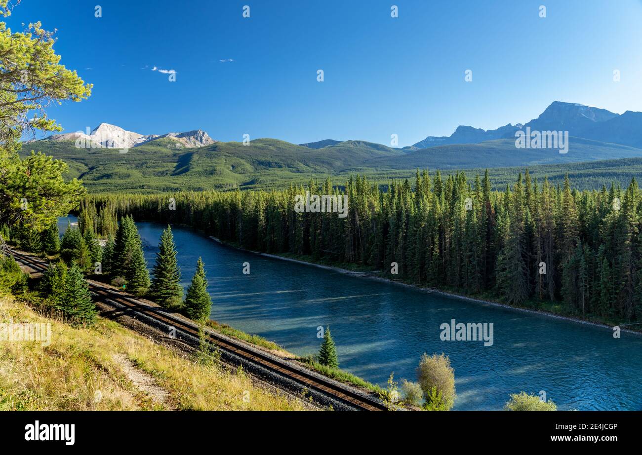 Bow River flows through forest and railway track. Storm Mountain in the ...