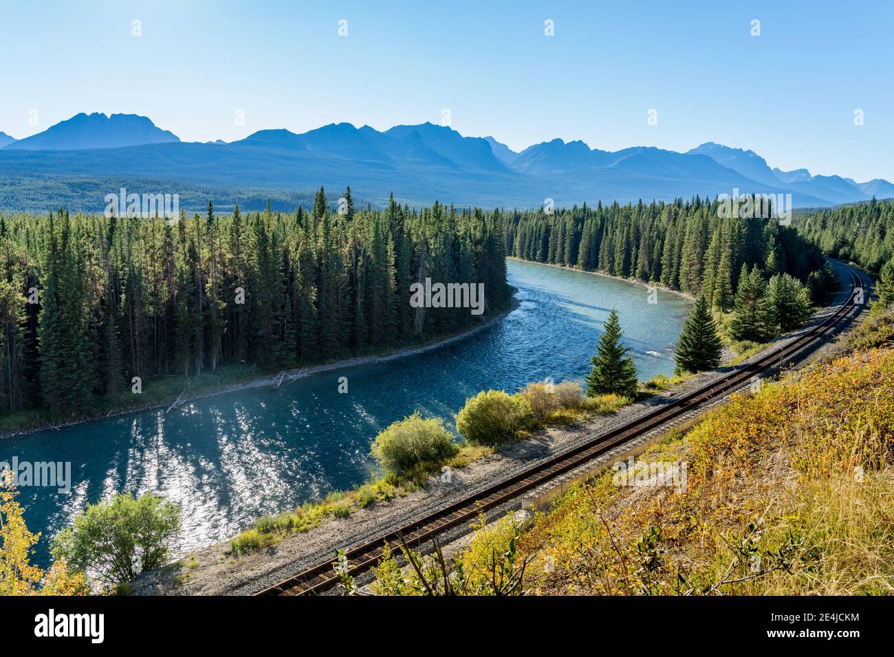 Bow River flows through forest and railway track. Storm Mountain in the ...