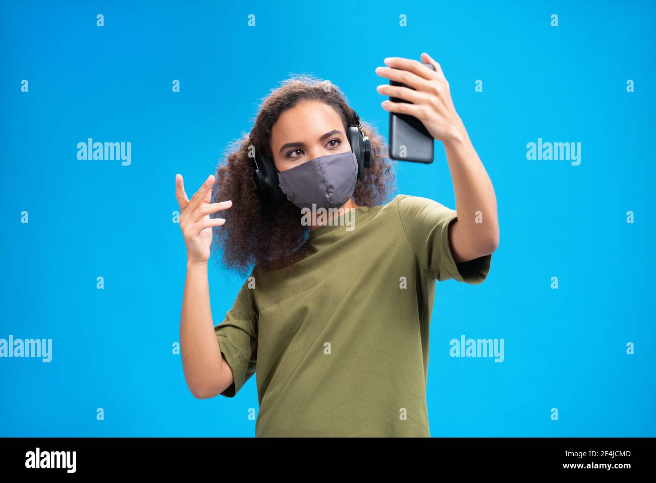 Talking on video call young African American girl using her smartphone ...