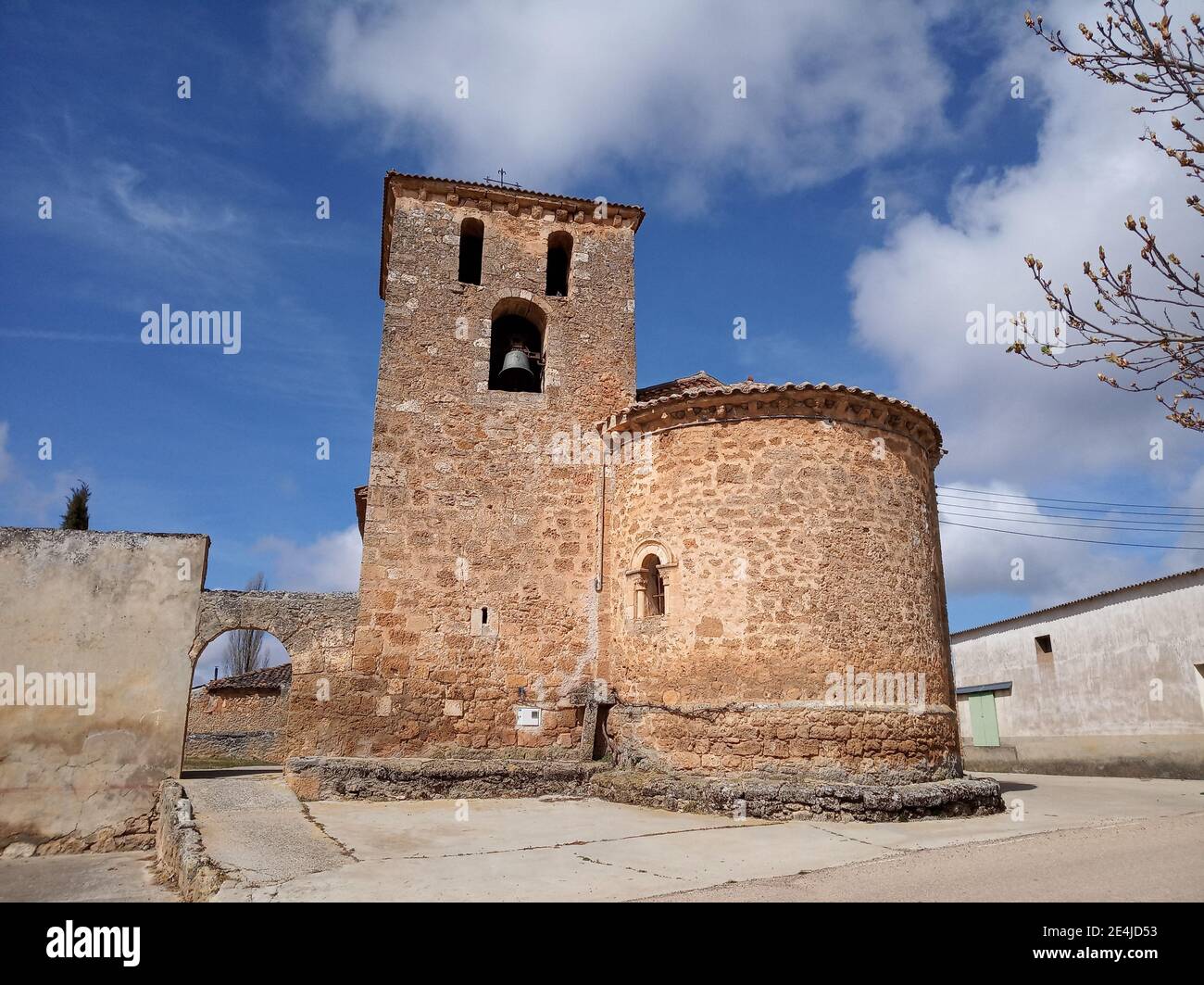 An old brick church with a bell in an arch window and a cross on top ...