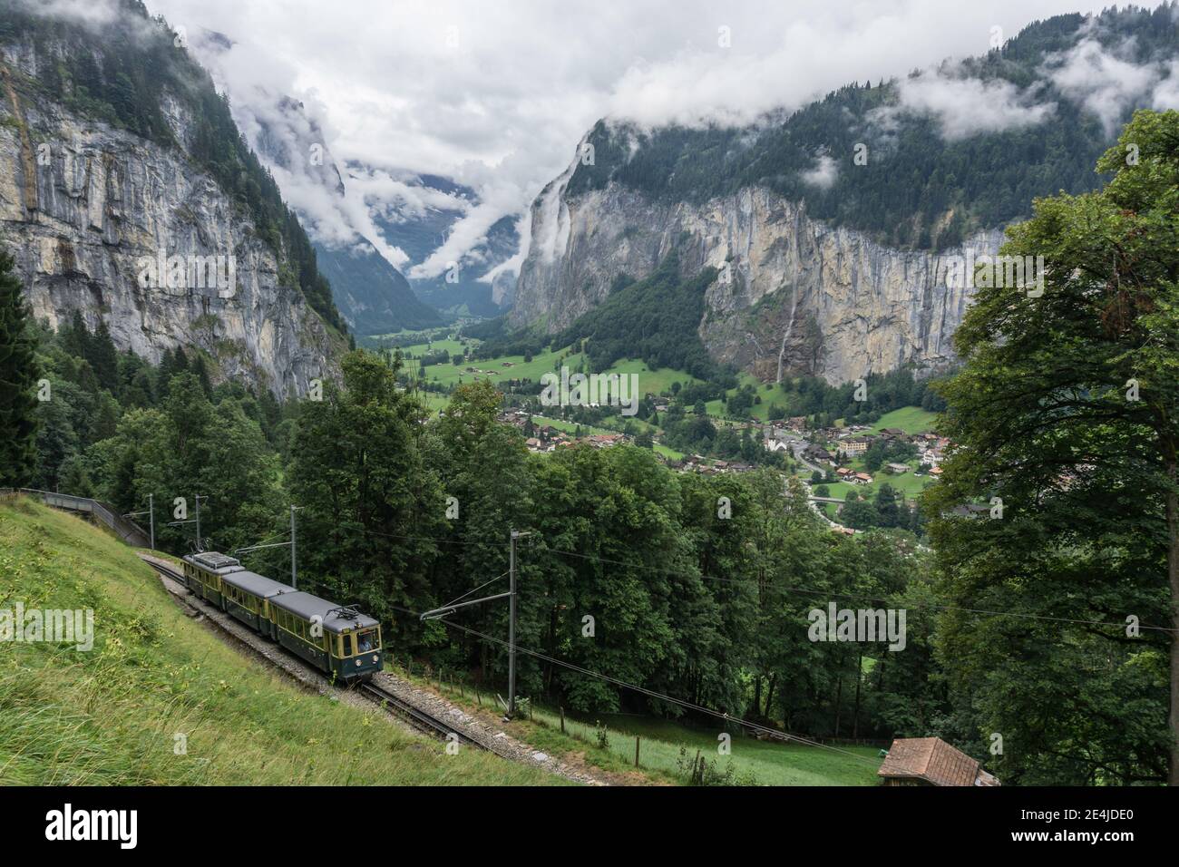 A Wengernalp Railway train climbs the hill from Lauterbrunnen to Wengen ...