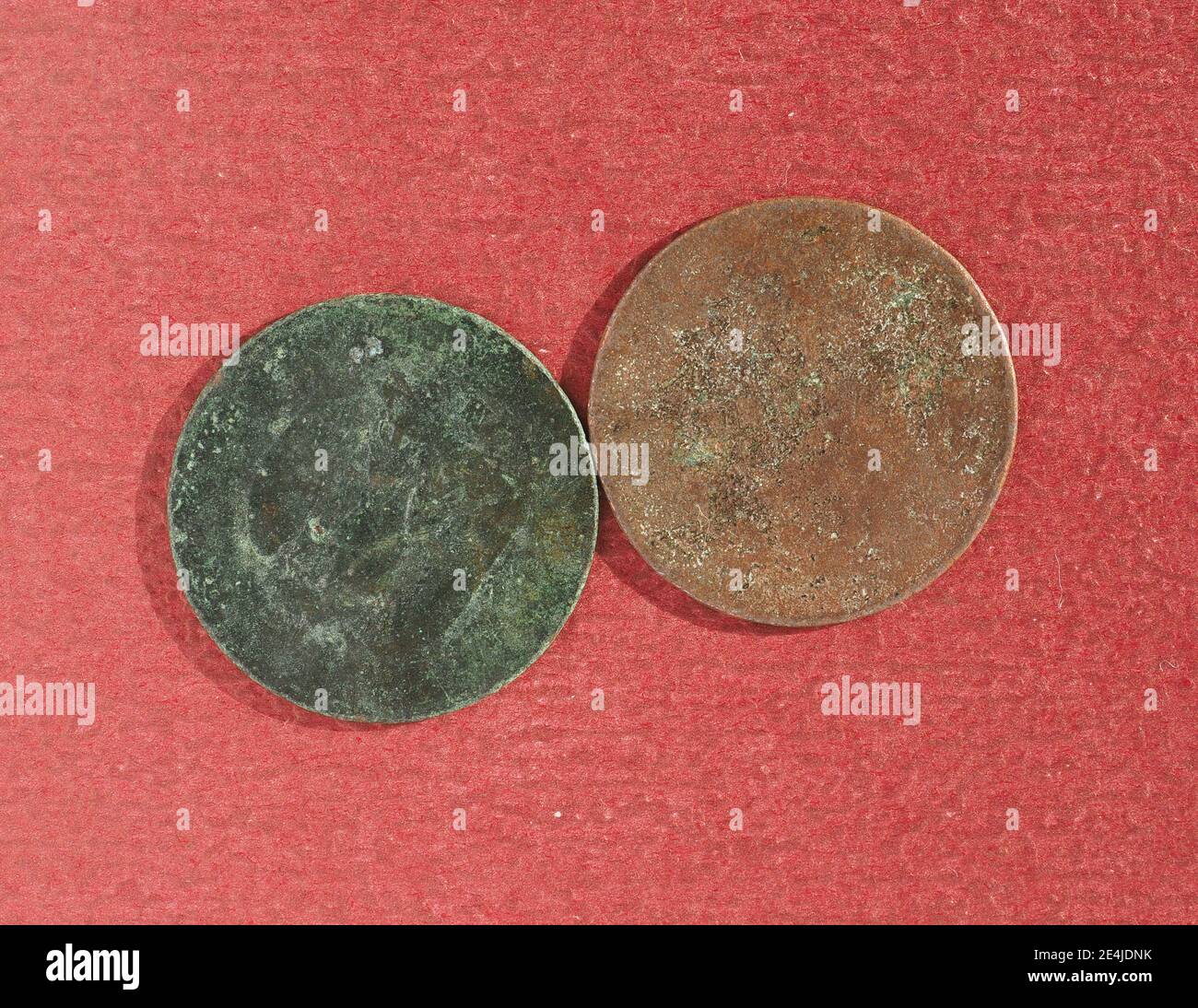 ancient unrecognisable rusted coin over red background Stock Photo - Alamy