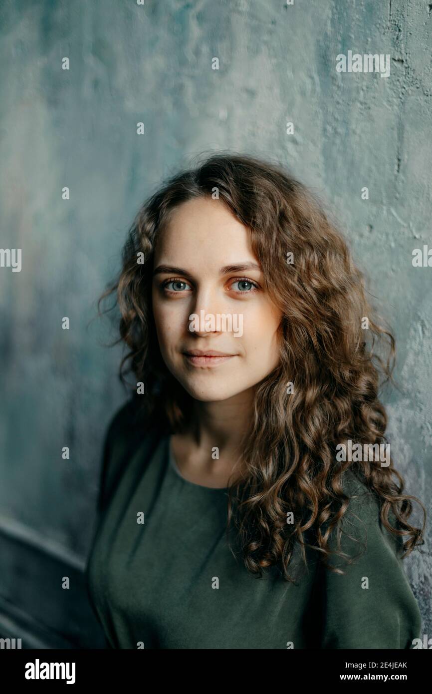 Beautiful woman staring while leaning on wall Stock Photo - Alamy