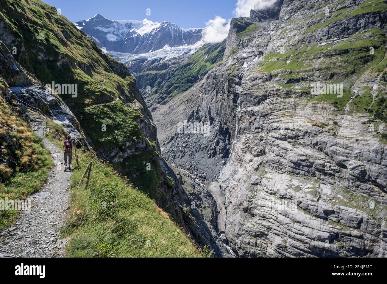 A hiker on the alpine path along the Lower Grindelwald Glacier, near ...