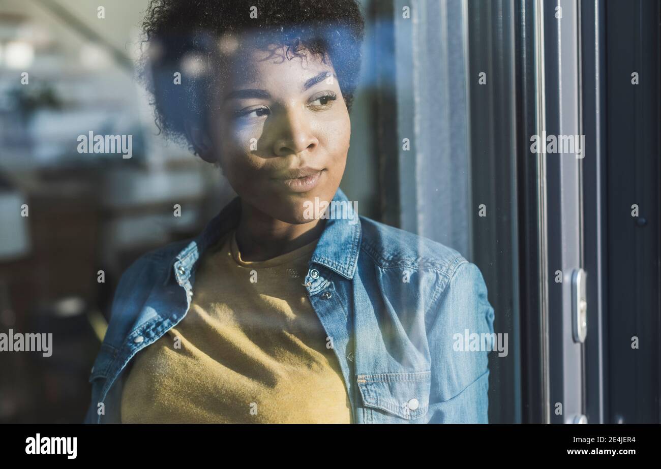 Woman looking through window Stock Photo - Alamy