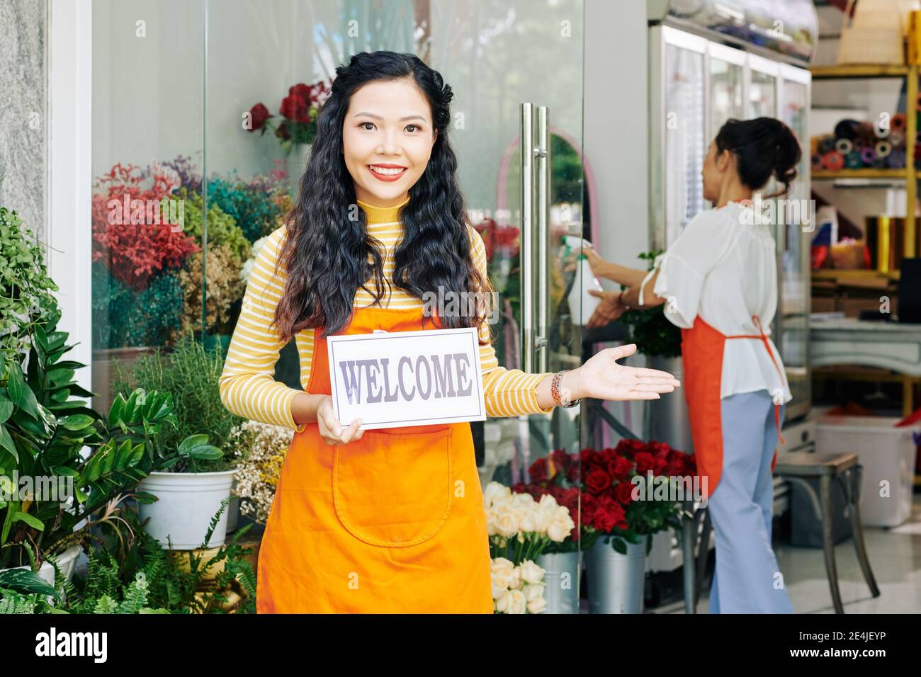 Florist holding welcome sign Stock Photo - Alamy
