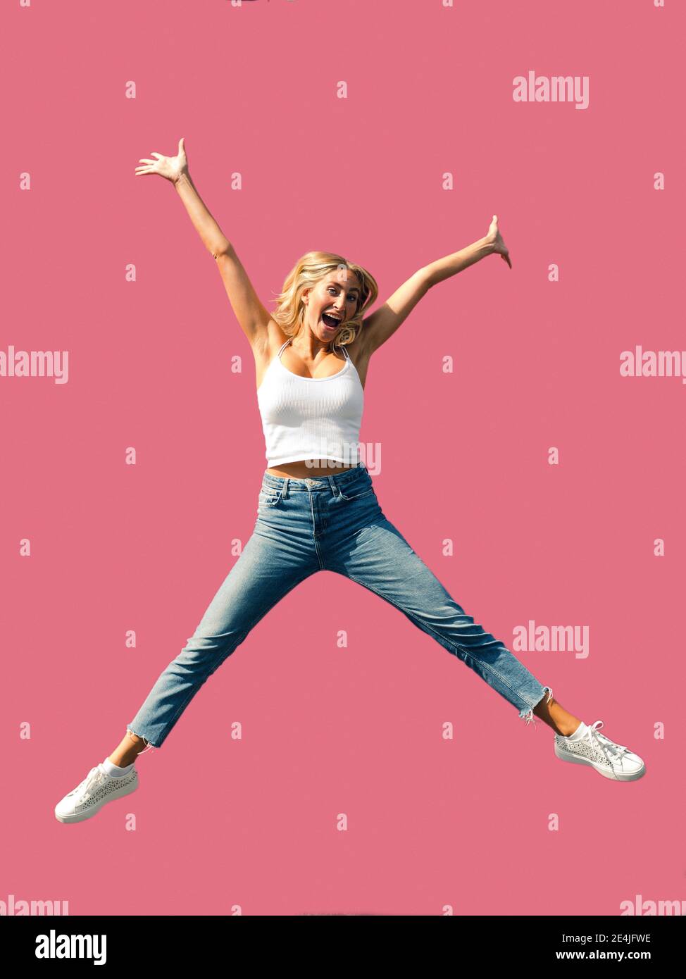 Beautiful woman jumping raising arms hi-res stock photography and ...