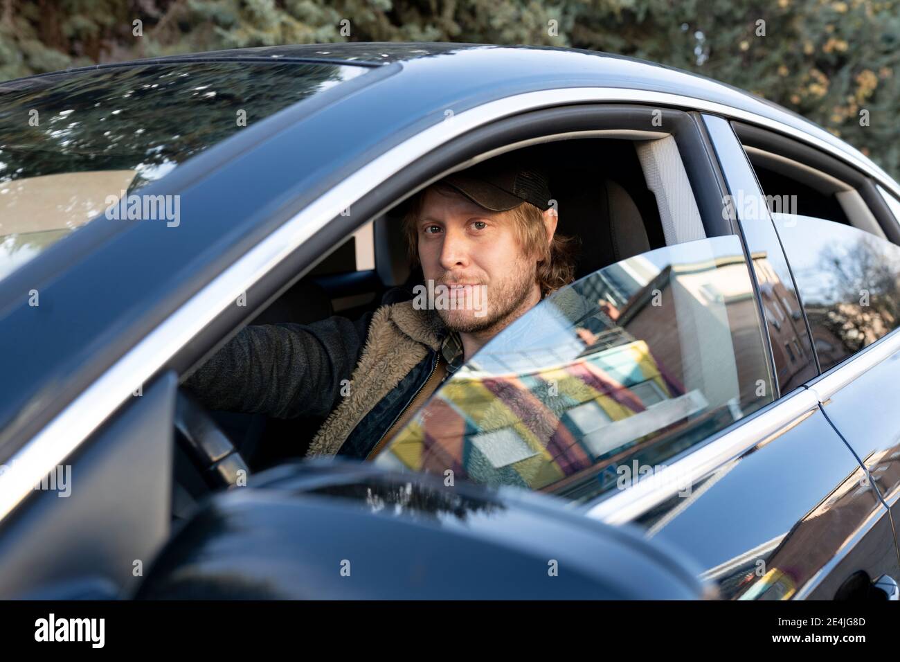 Man driving car seen through window Stock Photo - Alamy