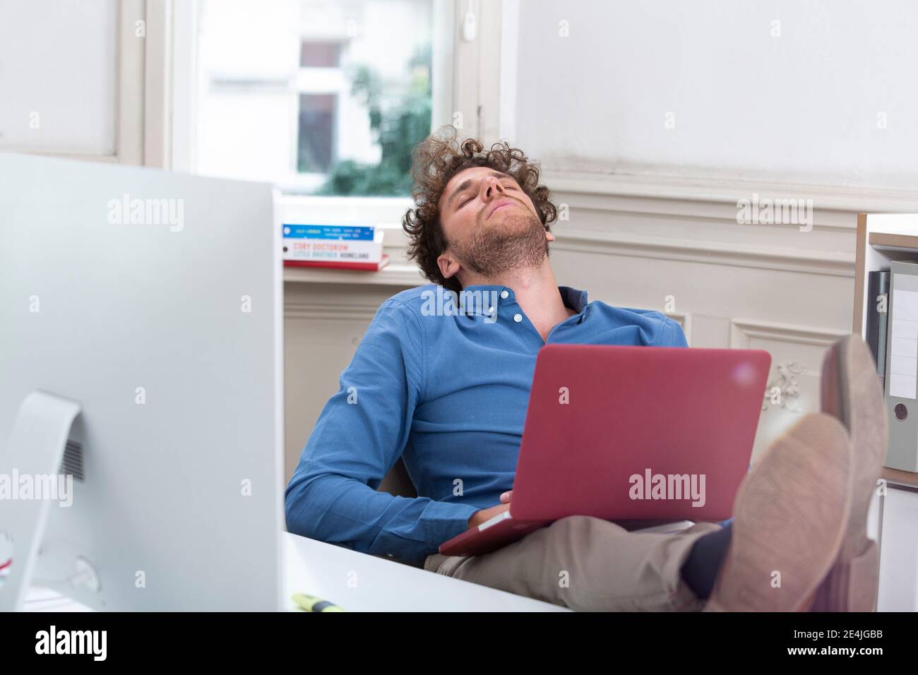 Young businessman sleeping with laptop in office cabin Stock Photo - Alamy