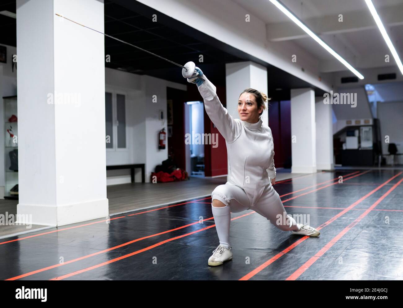 Woman in fencing outfit practicing at gym Stock Photo - Alamy