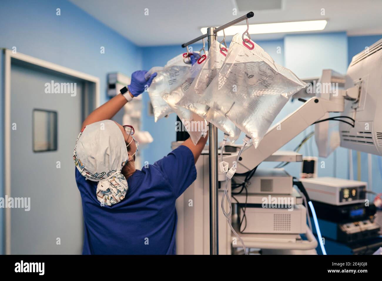 Male doctor removing IV drip bag while standing by monitoring machine ...