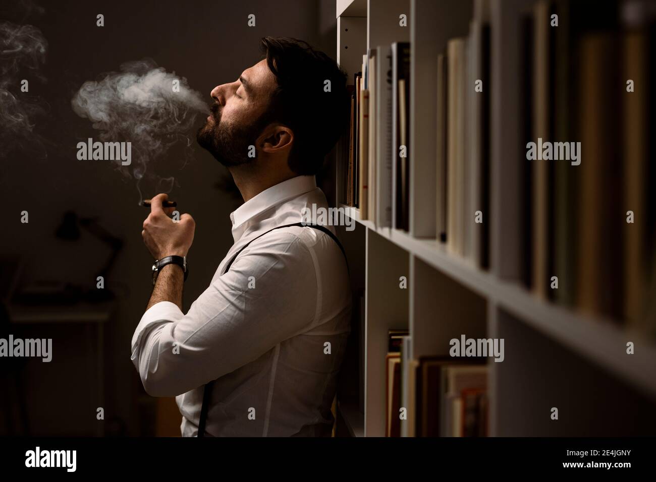 Man standing in front bookshelf hi-res stock photography and images - Alamy