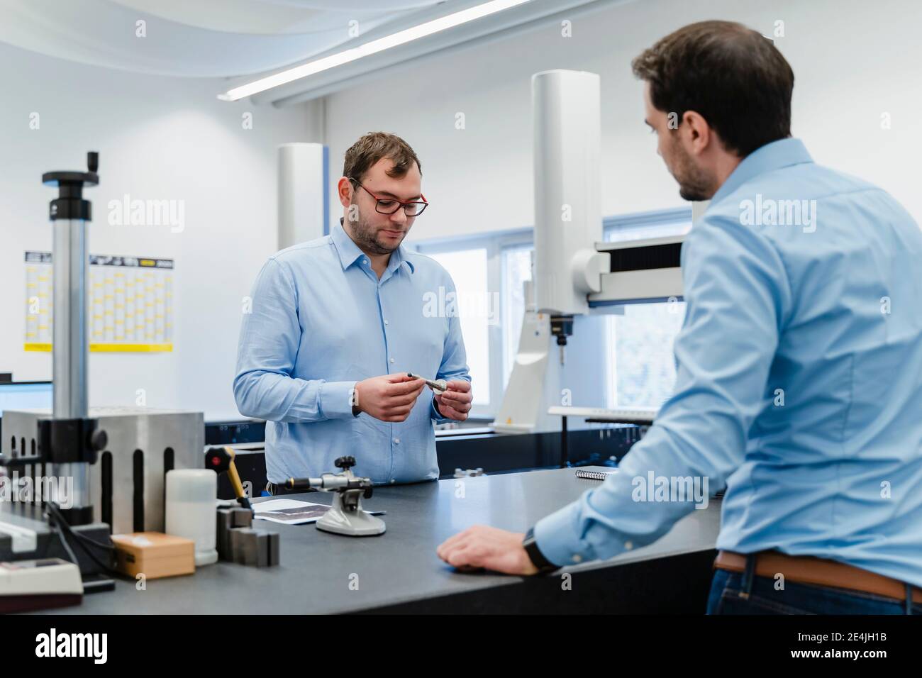 Engineers examining equipment while standing in measuring room at ...