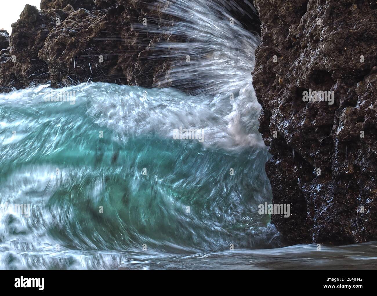 Green waves hit a cliff in slow motion Stock Photo - Alamy