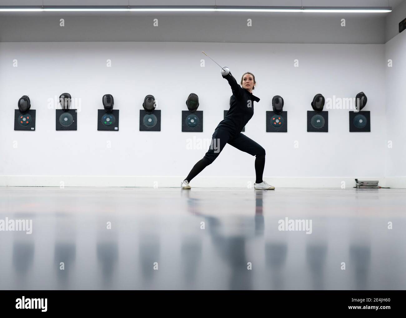 Woman in fencing outfit practicing at gym Stock Photo - Alamy