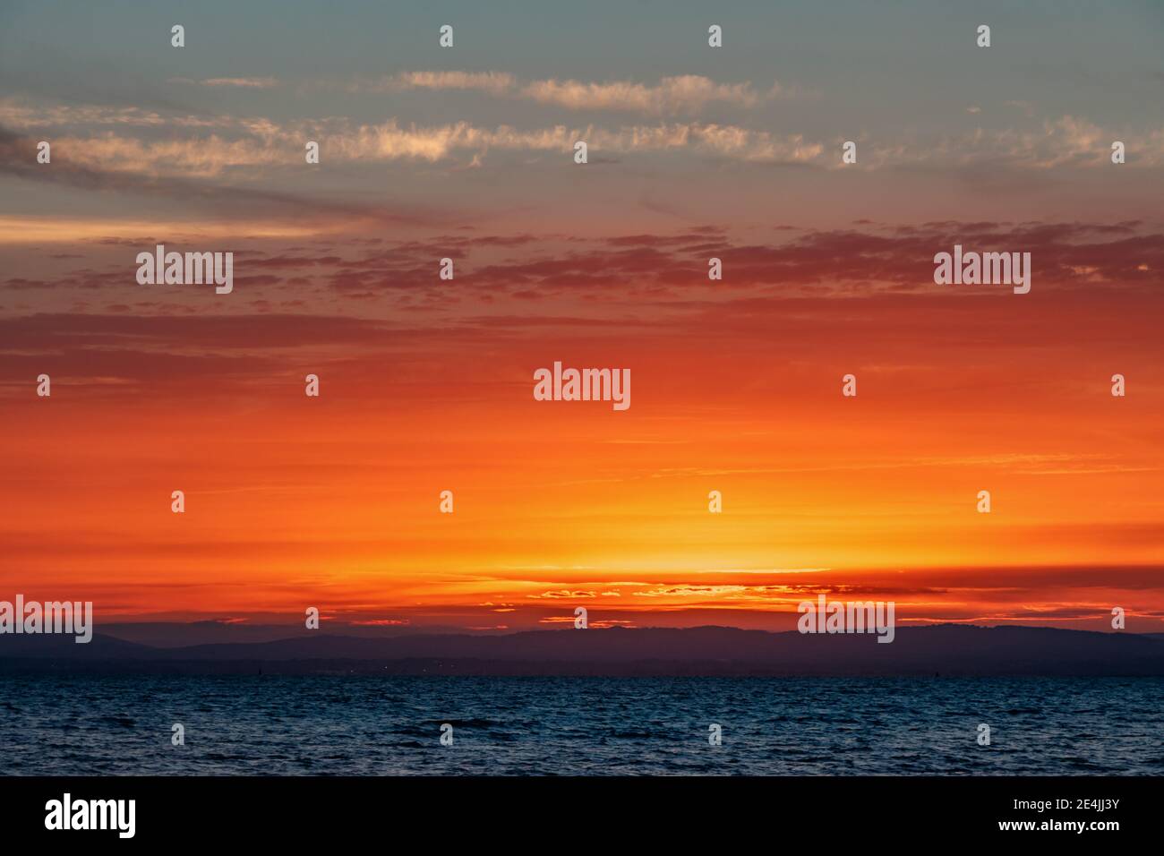 The sun setting over the horizon Stock Photo - Alamy