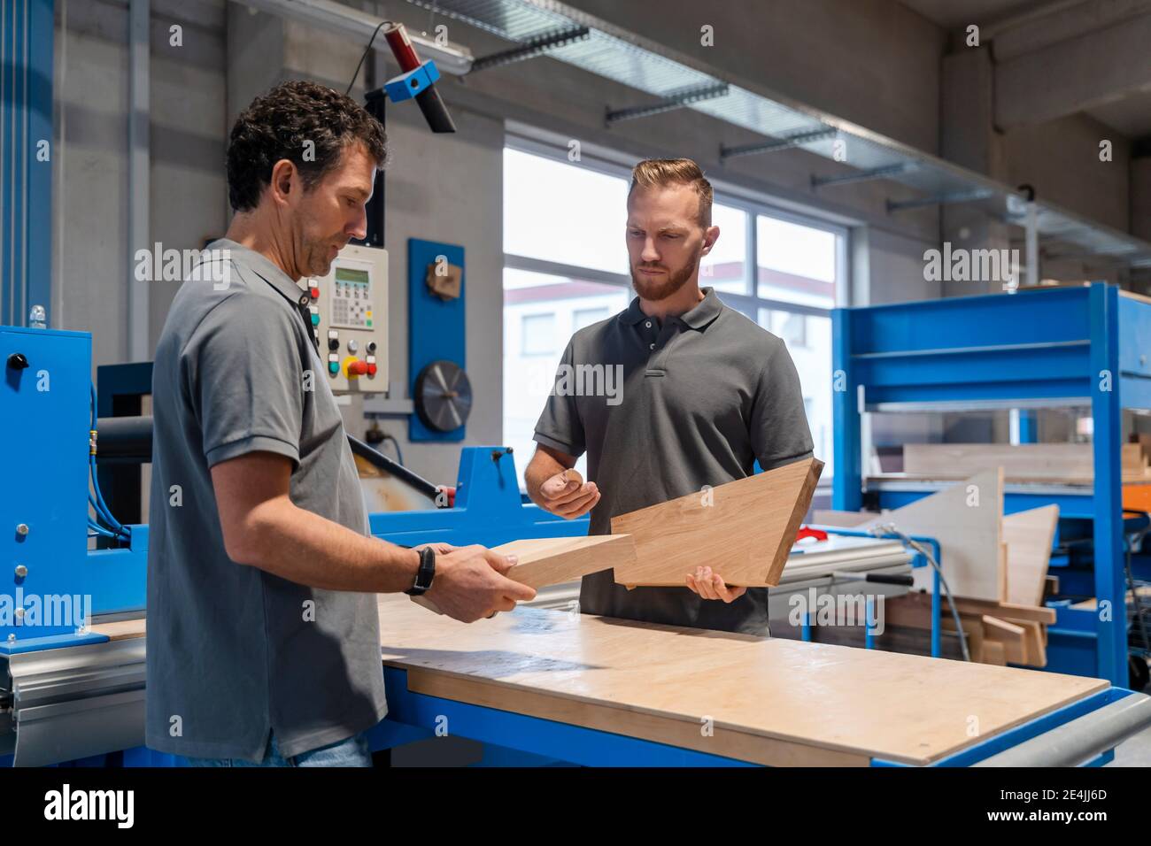Two male carpenters talking in production hall Stock Photo - Alamy