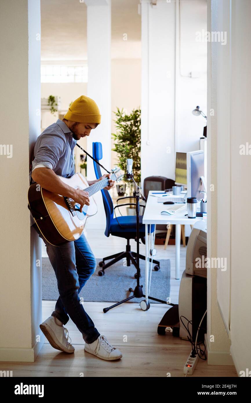 Guitarist playing guitar while standing at studio Stock Photo - Alamy