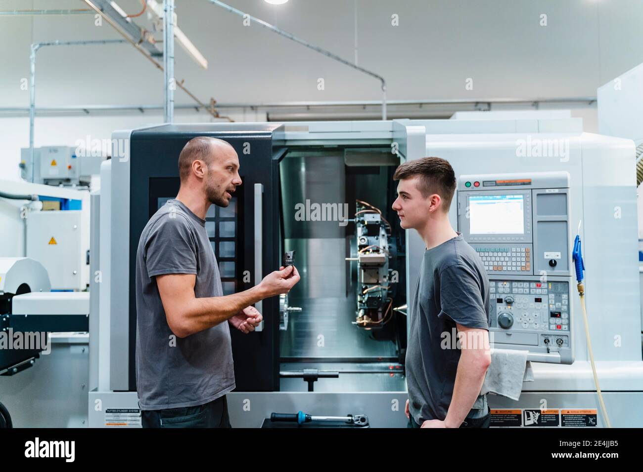 Maintenance engineer giving instruction to coworker while standing ...