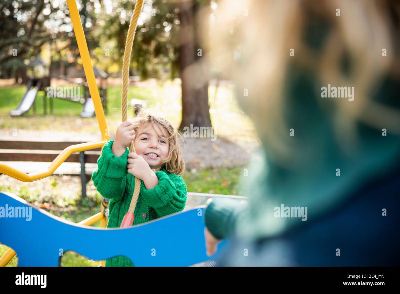 Smiling girl pulling rope while playing with mother at park Stock Photo ...