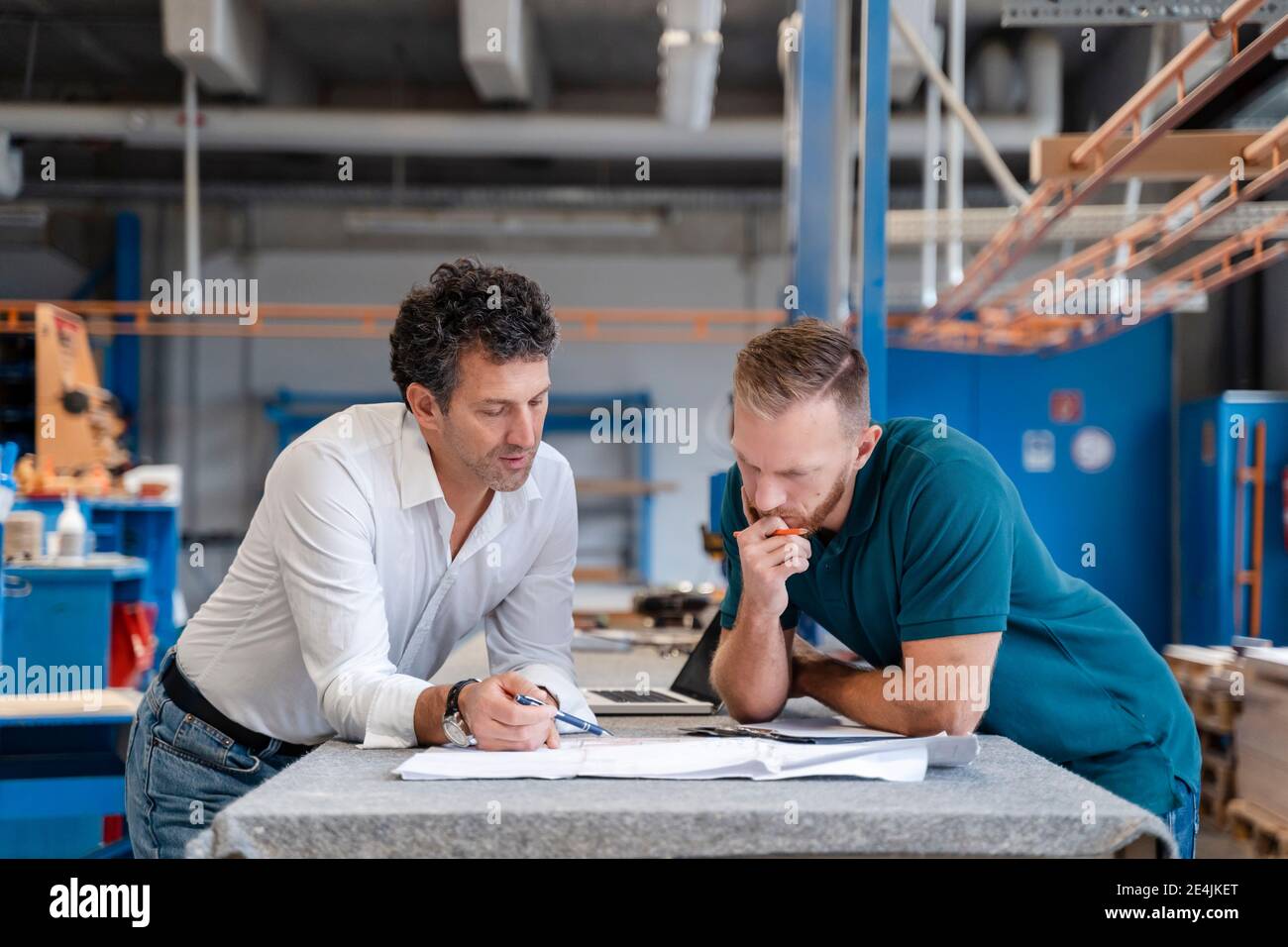 Two men leaning over table hi-res stock photography and images - Alamy