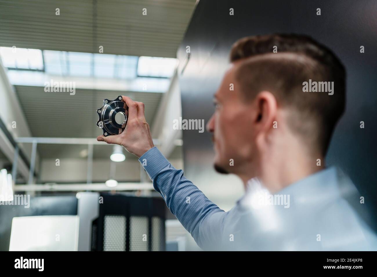 Businessman looking at machine part at in factory Stock Photo - Alamy