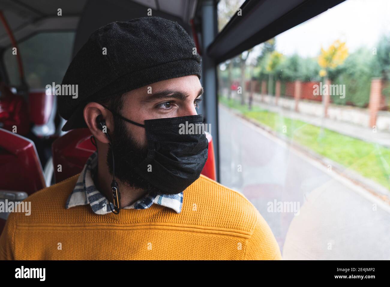 Commuter looking through window while listening music in bus Stock ...