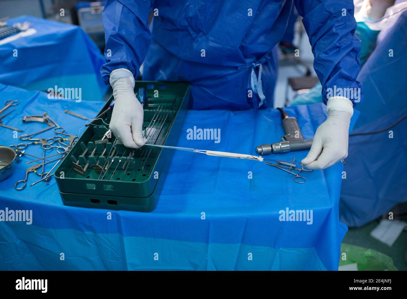 Male surgeon with hands clasped seen through door glass window in ...