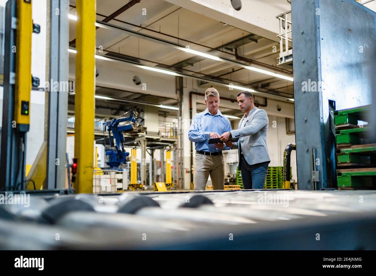 Male entrepreneur with coworker looking at document while working in ...