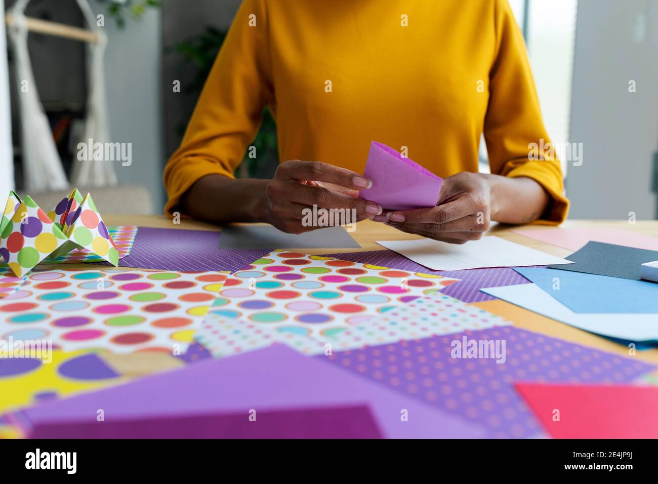 Origami artist sitting in studio folding colorful paper Stock Photo - Alamy
