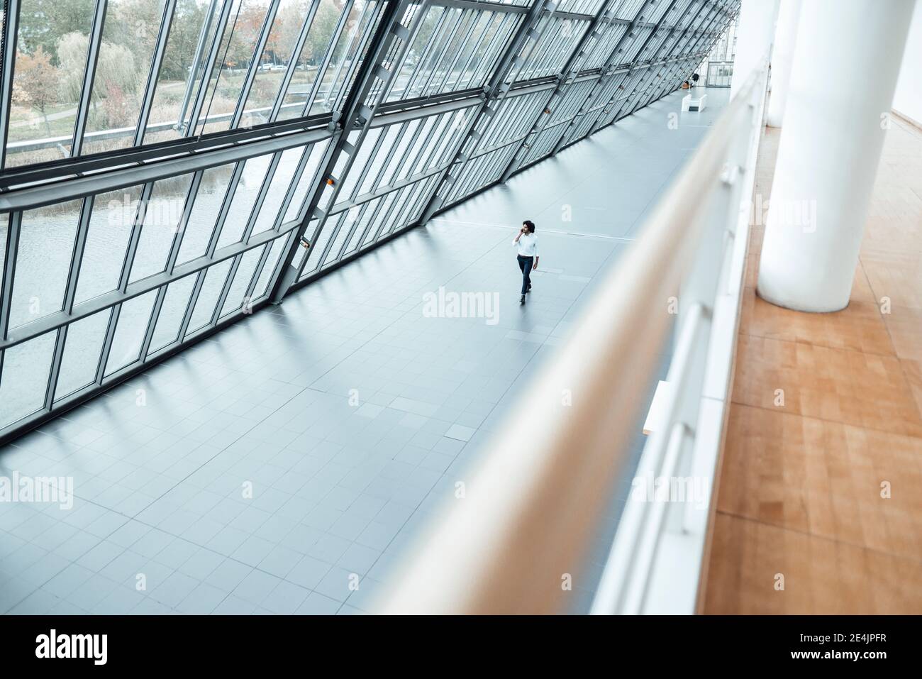 Young male entrepreneur walking by roof in office corridor Stock Photo ...