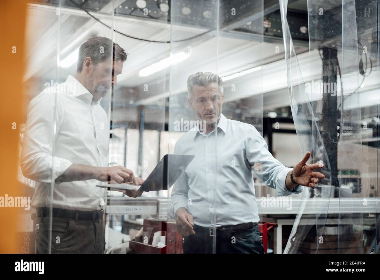Professionals examining equipment while standing in workshop at ...