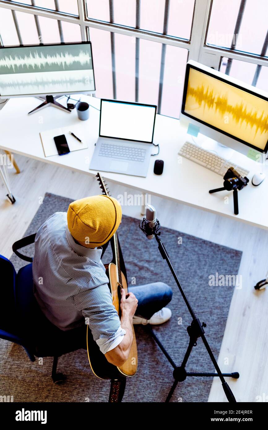 Vlogger live streaming on camera while playing guitar at recording ...