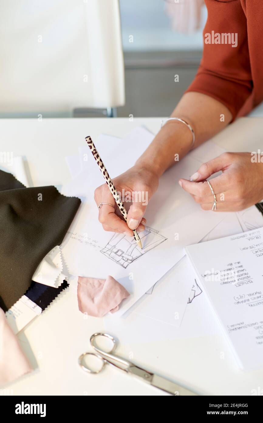 Female design professional drawing on paper at desk in atelier Stock ...
