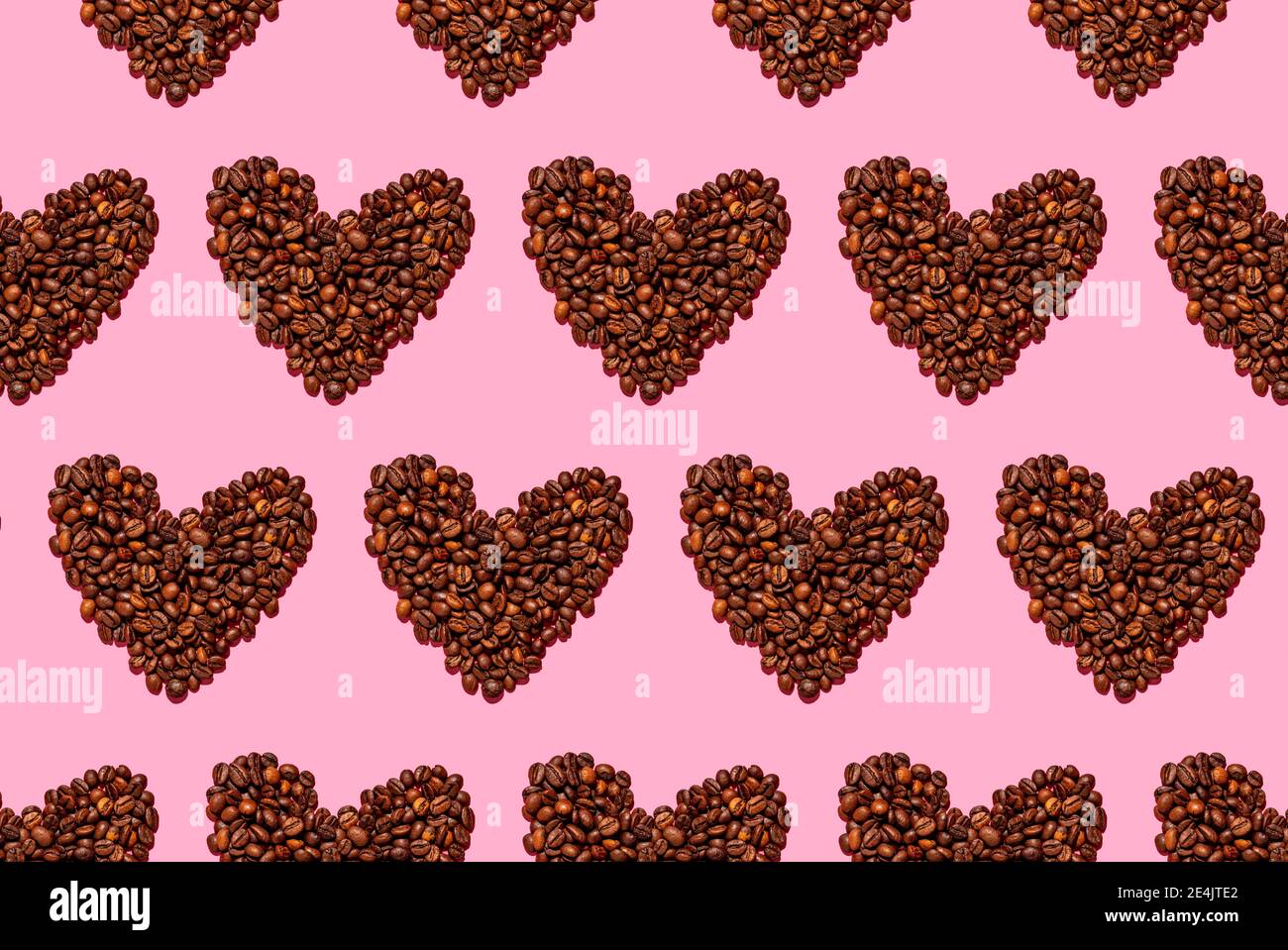 Pattern of roasted coffee beans arranged into heart shapes Stock Photo ...